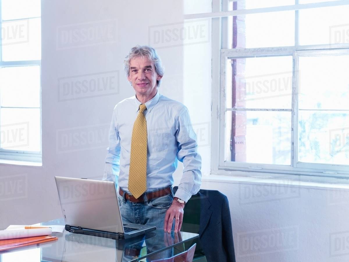 Businessman standing at table - Royalty-free Stock Photo | Dissolve