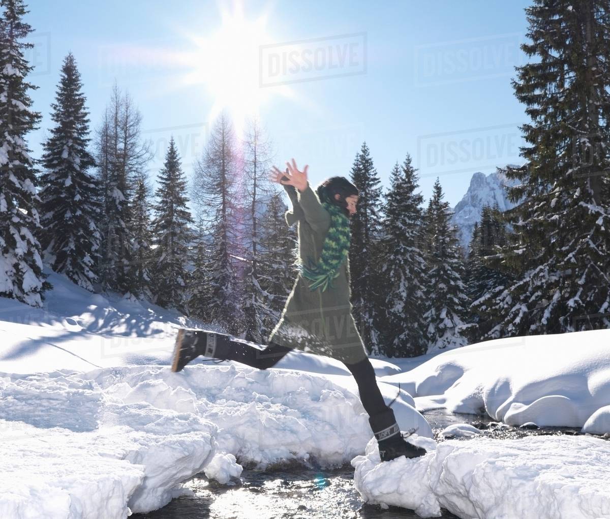 Woman jumping across stream - Royalty-free Stock Photo | Dissolve