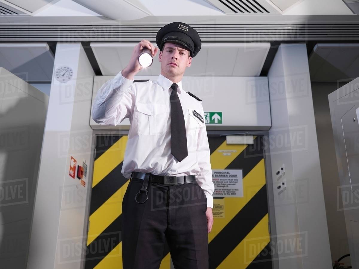 Security guard with torch - Stock Photo - Dissolve