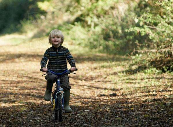 Boy riding bike in countryside - Royalty-free Stock Photo | Dissolve
