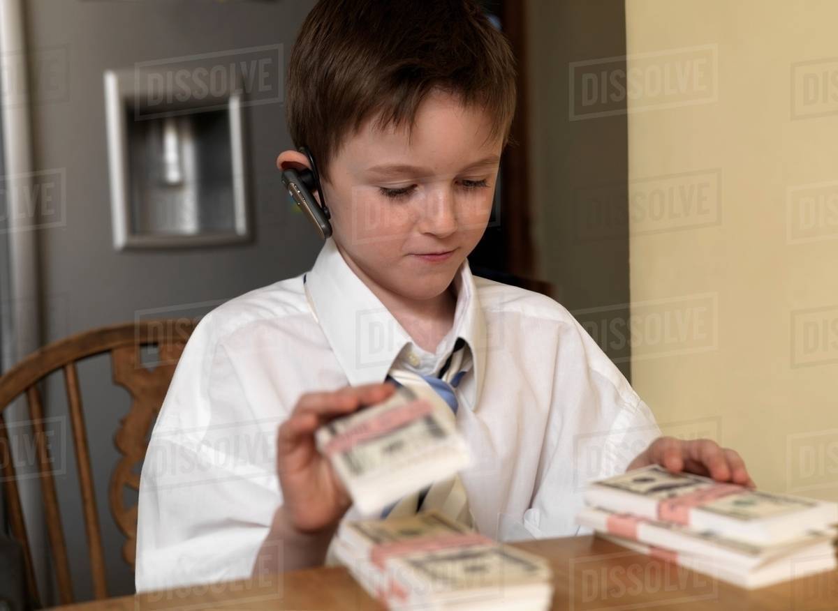 Boy counting money at table - Royalty-free Stock Photo | Dissolve