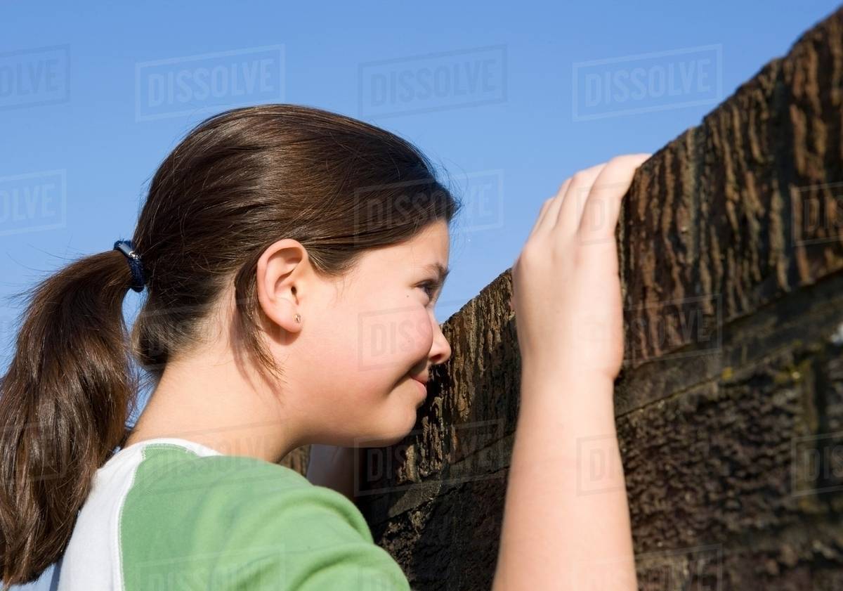Girl looking over wall - Royalty-free Stock Photo | Dissolve