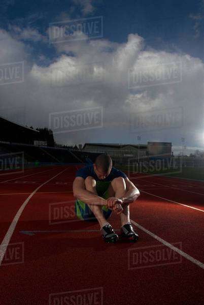 Athlete sitting on track - Royalty-free Stock Photo | Dissolve