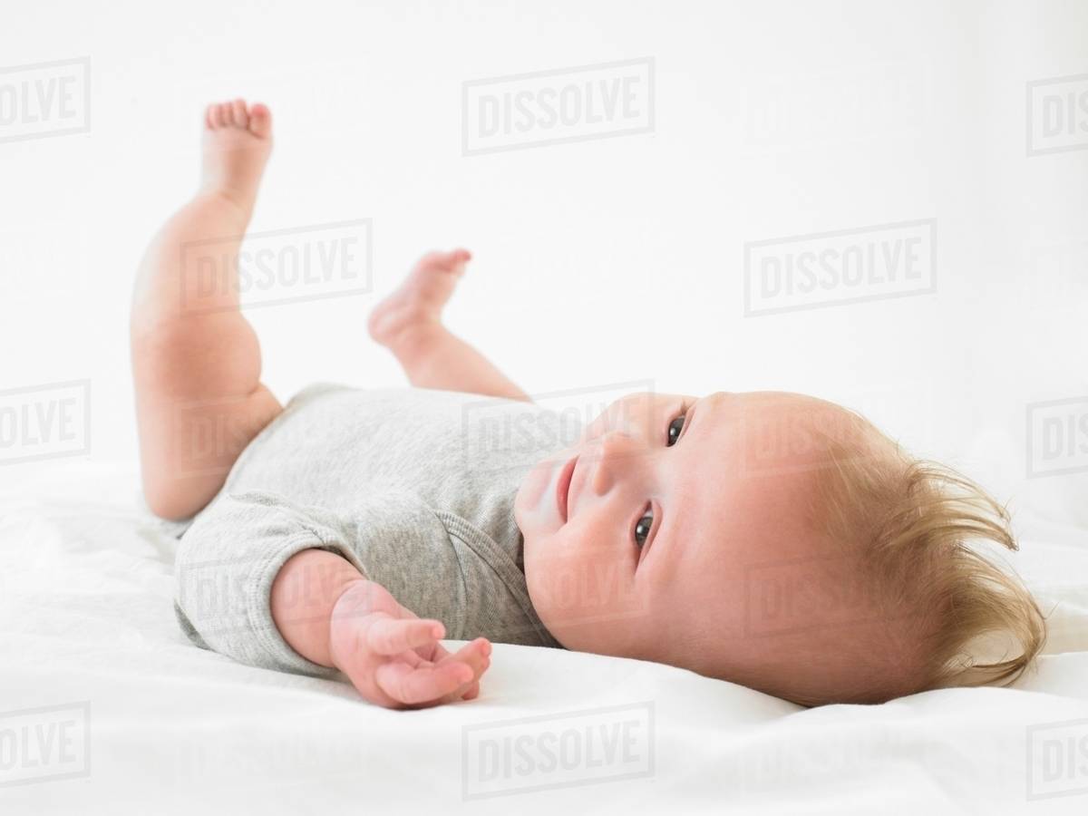 Baby on back, smiling - Stock Photo - Dissolve