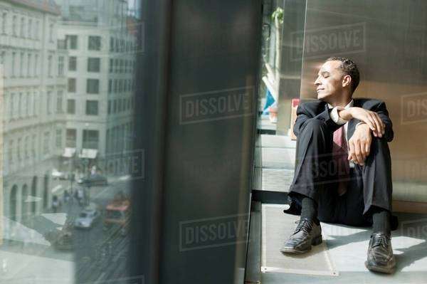 Man on floor looking out a window - Royalty-free Stock Photo | Dissolve