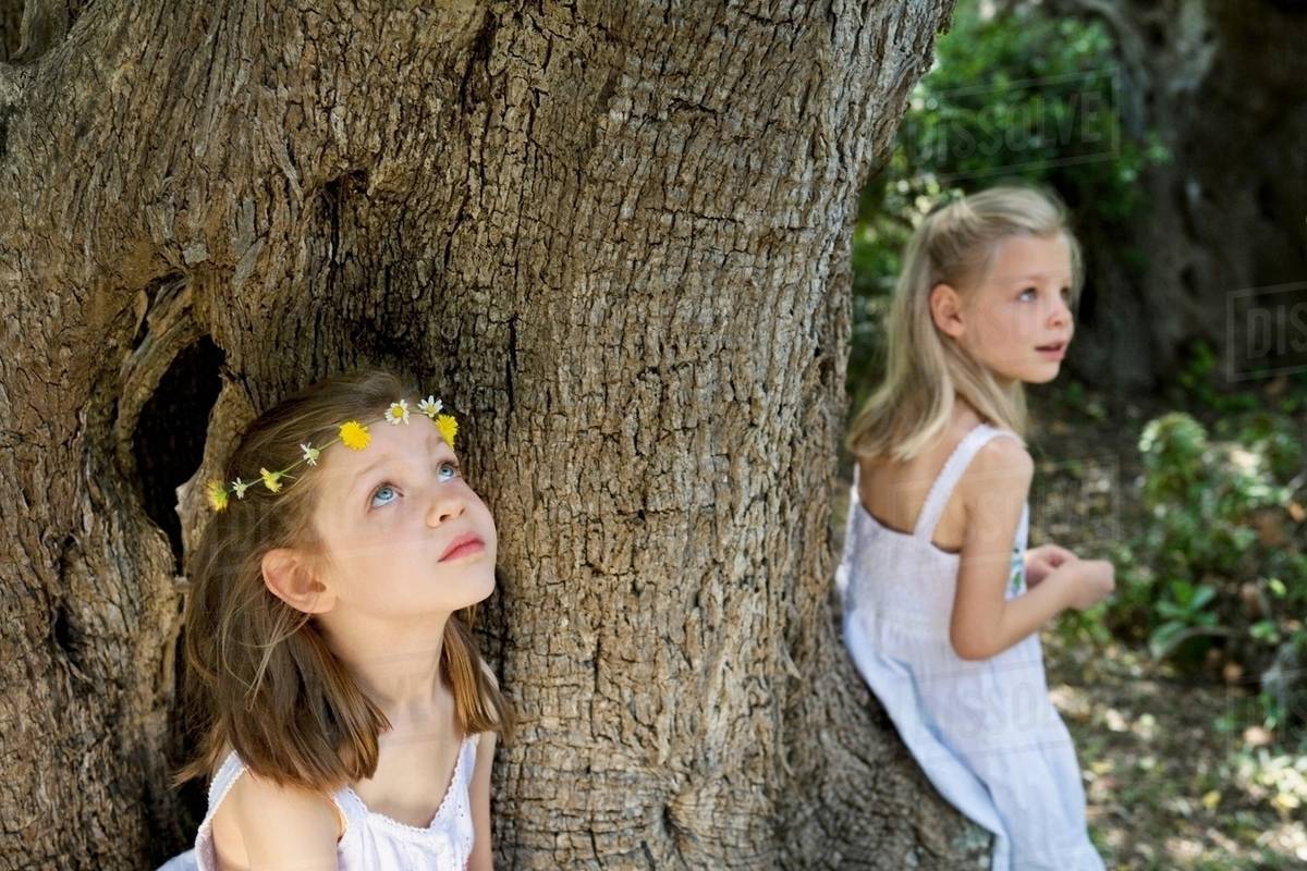 A portrait of two girls by a tree - Royalty-free Stock Photo | Dissolve