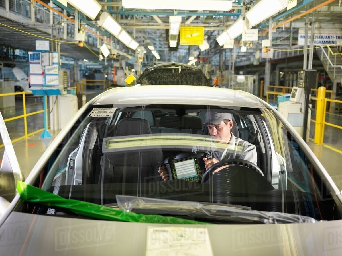 Car Worker In Car On Production Line - Stock Photo - Dissolve
