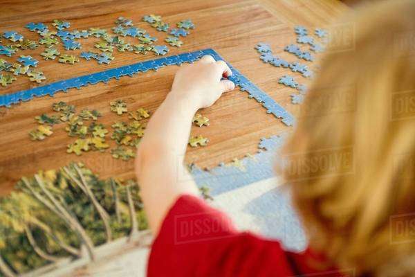 Portrait of a child doing a puzzle - Royalty-free Stock Photo | Dissolve