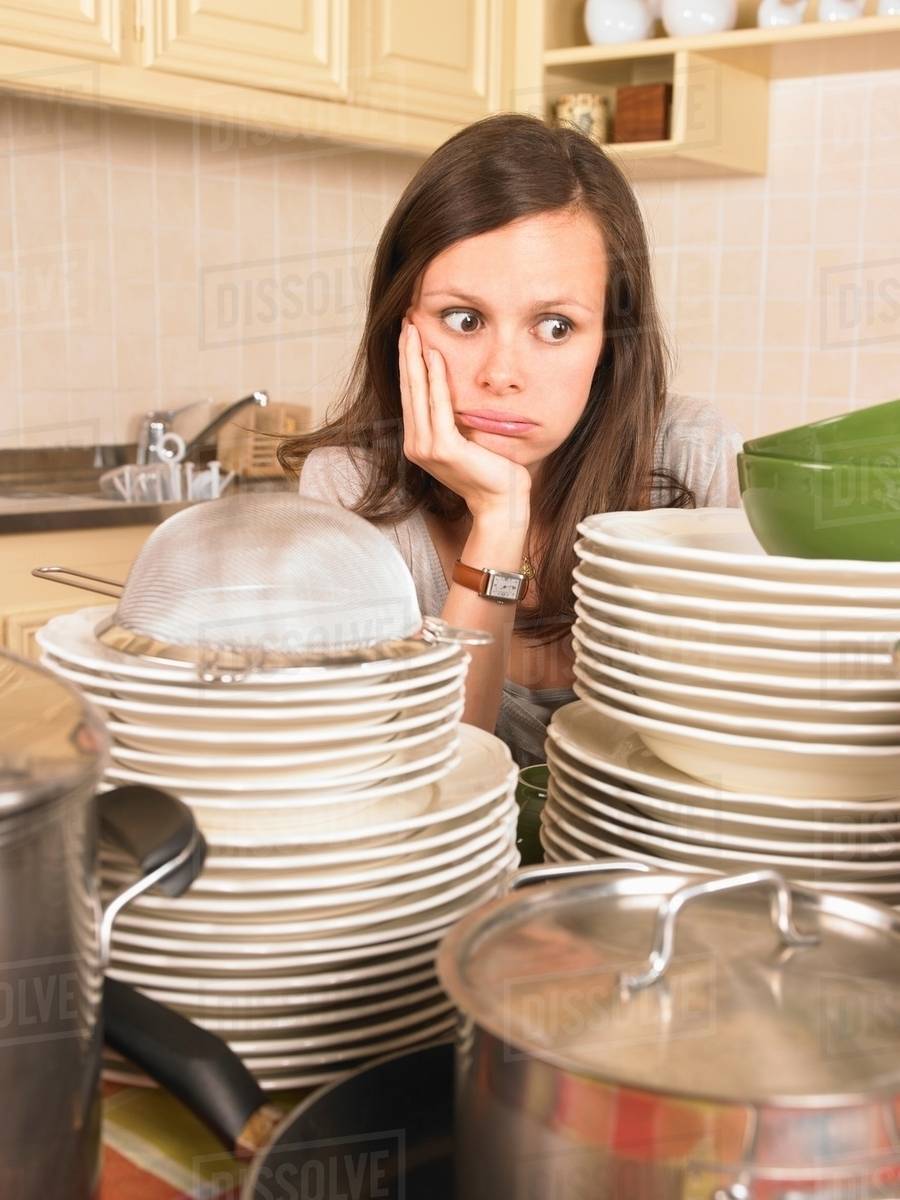 Woman with piles of washing up - Stock Photo - Dissolve