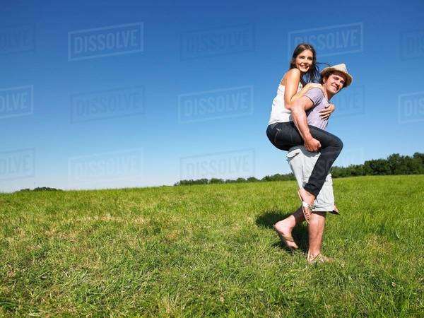 Young people riding piggy back - Stock Photo - Dissolve