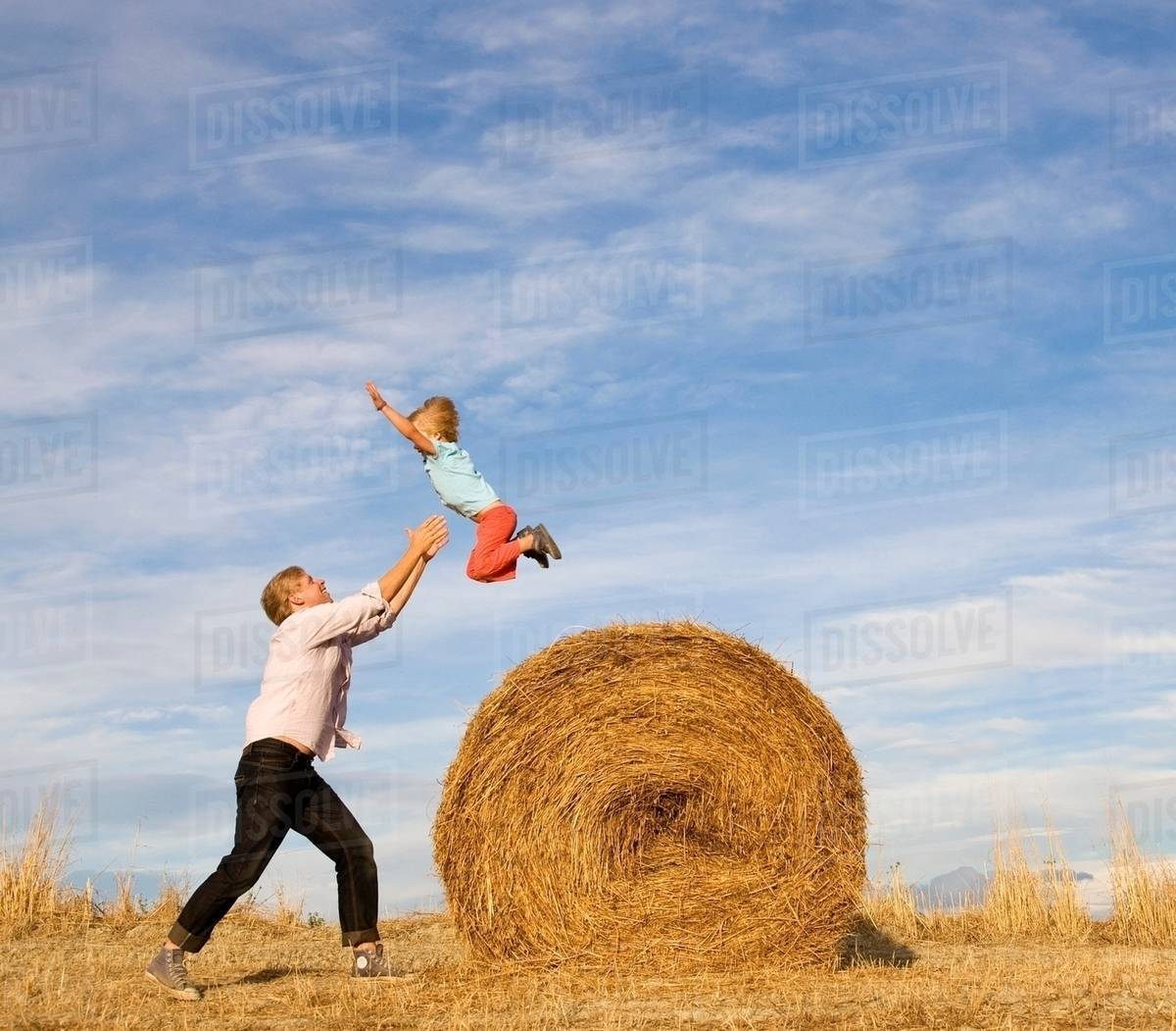 Man catching boy jumping from hay bale - Royalty-free Stock Photo ...