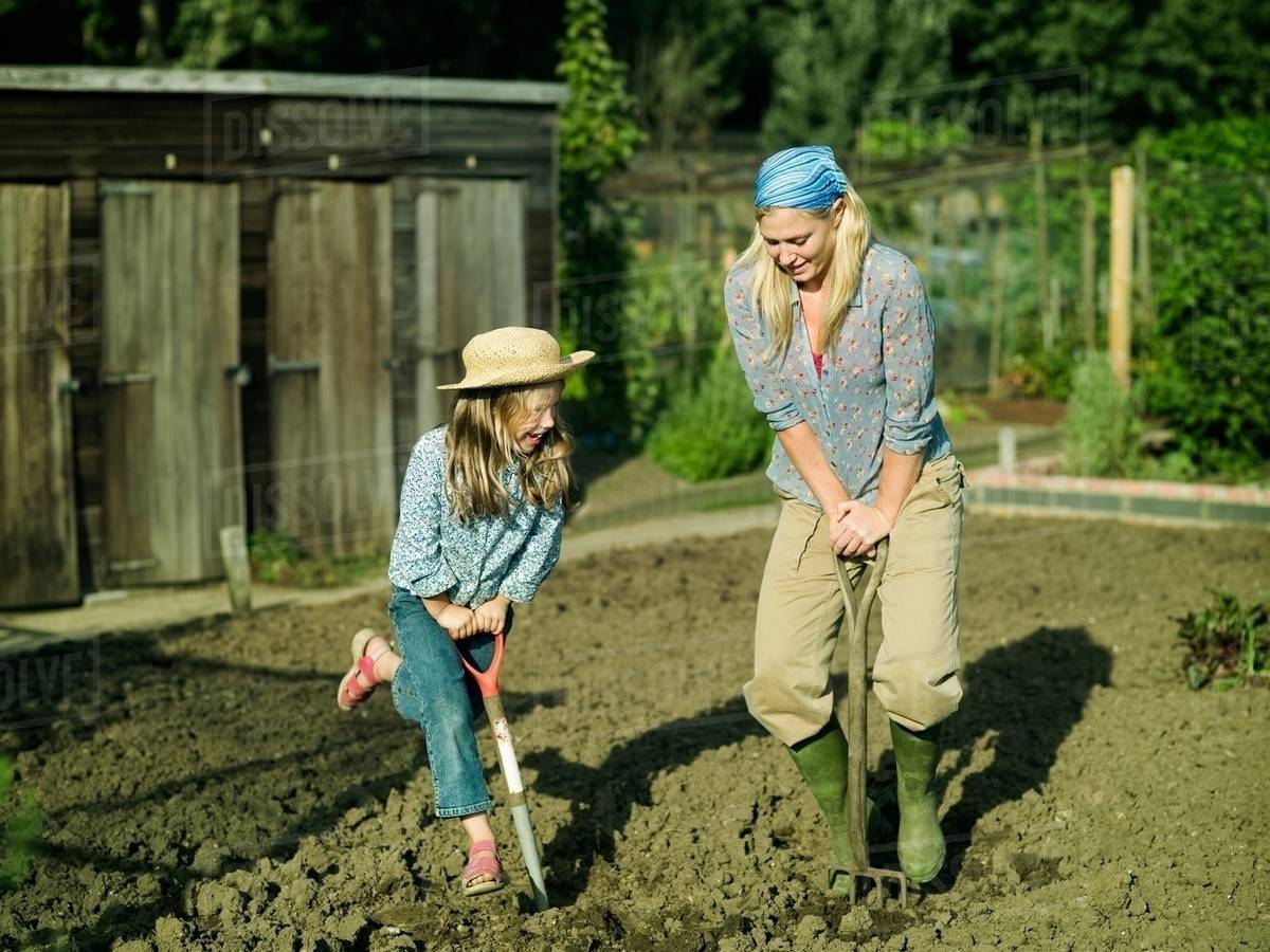 A woman and girl digging a garden - Royalty-free Stock Photo | Dissolve