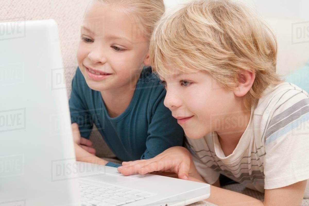 A boy and girl using a laptop - Stock Photo - Dissolve
