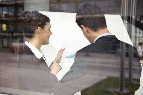 Business people looking at paperwork - Stock Photo - Dissolve