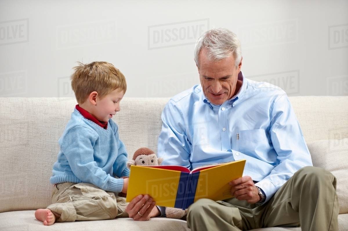 Young boy and grandfather reading book - Royalty-free Stock Photo ...