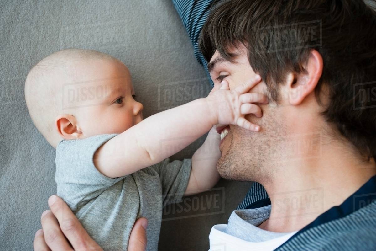 Baby touching fathers face - Stock Photo - Dissolve