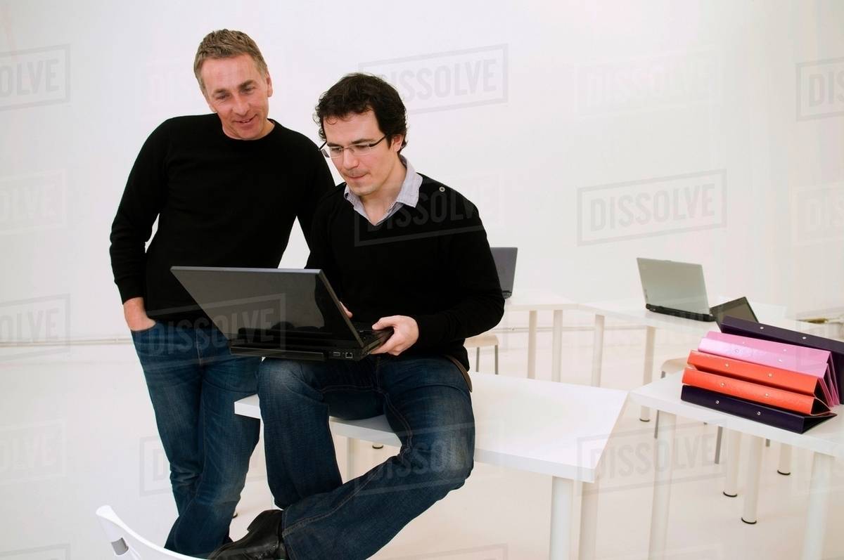 Two relaxed business men look at laptop - Royalty-free Stock Photo ...