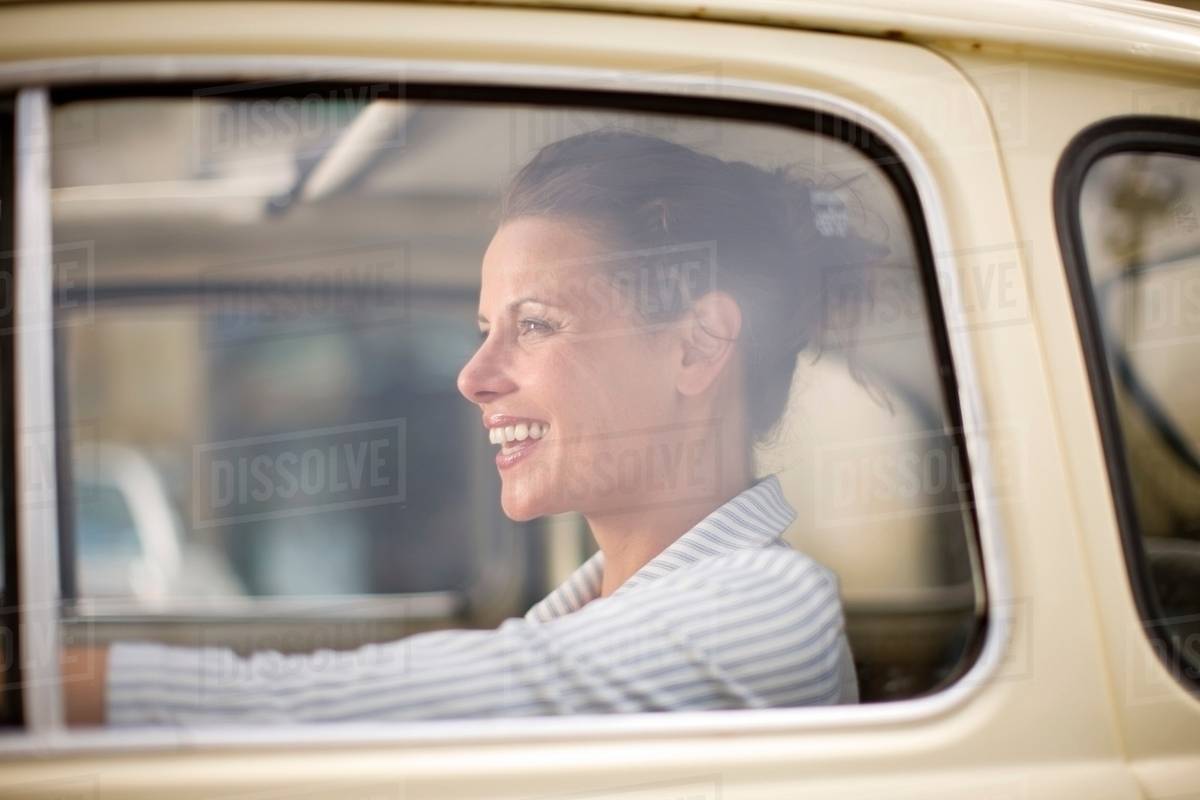 Woman smiling in car - Royalty-free Stock Photo | Dissolve