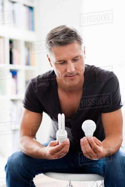 Man holding light bulbs - Stock Photo - Dissolve