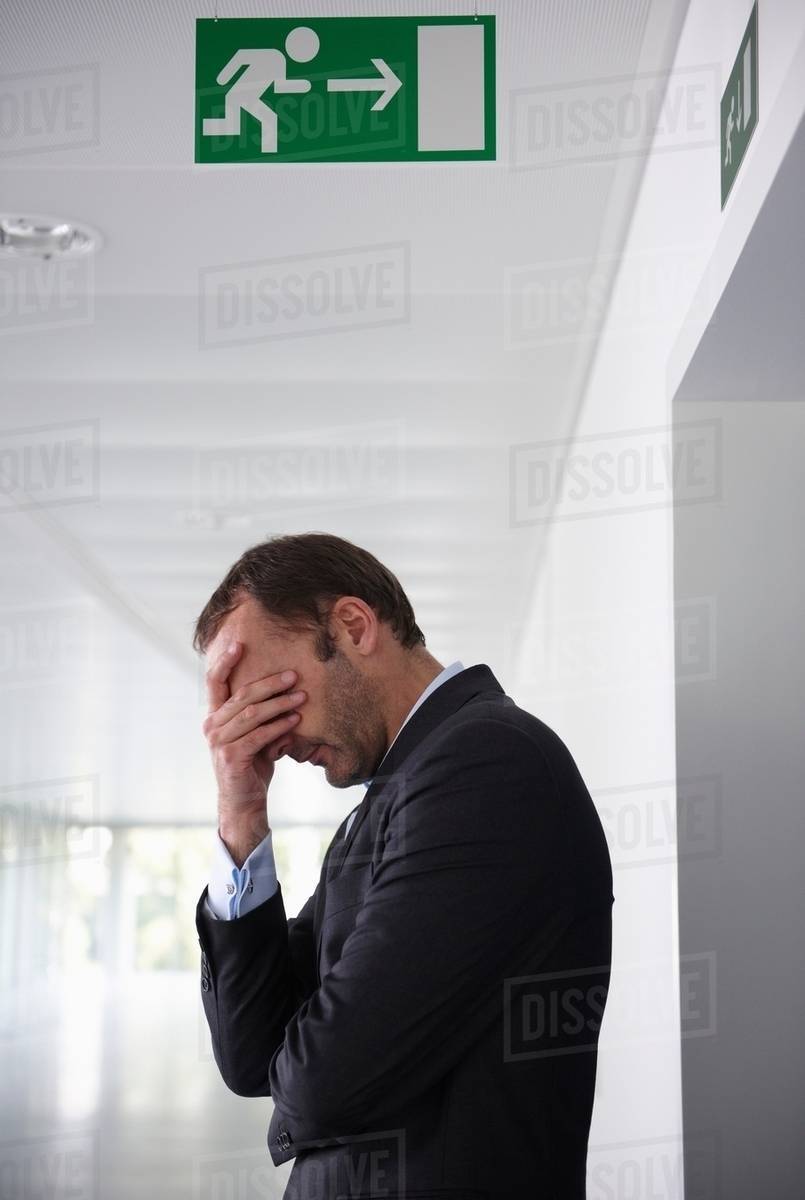 Businessman in empty office, sad - Stock Photo - Dissolve