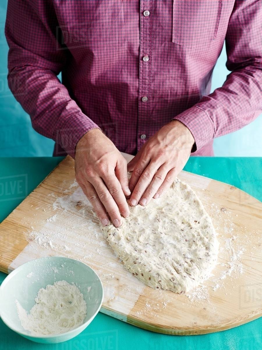 Man preparing unkneaded bread recipe step 2, shaping bread dough ...