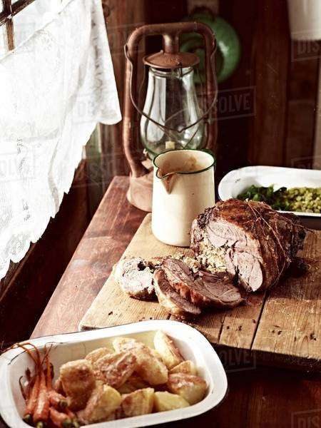 Rustic table with roasted goose on chopping board and roasted ...