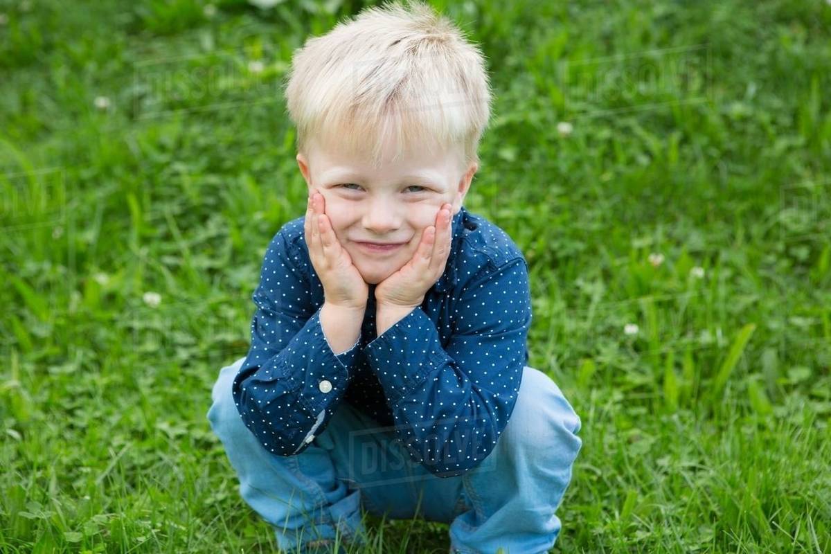Portrait of male toddler crouching in garden - Royalty-free Stock Photo ...