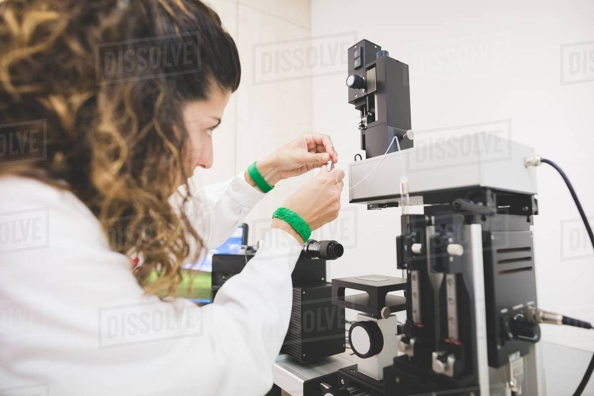 Female scientist looking at contact angle, preparing instrument for ...