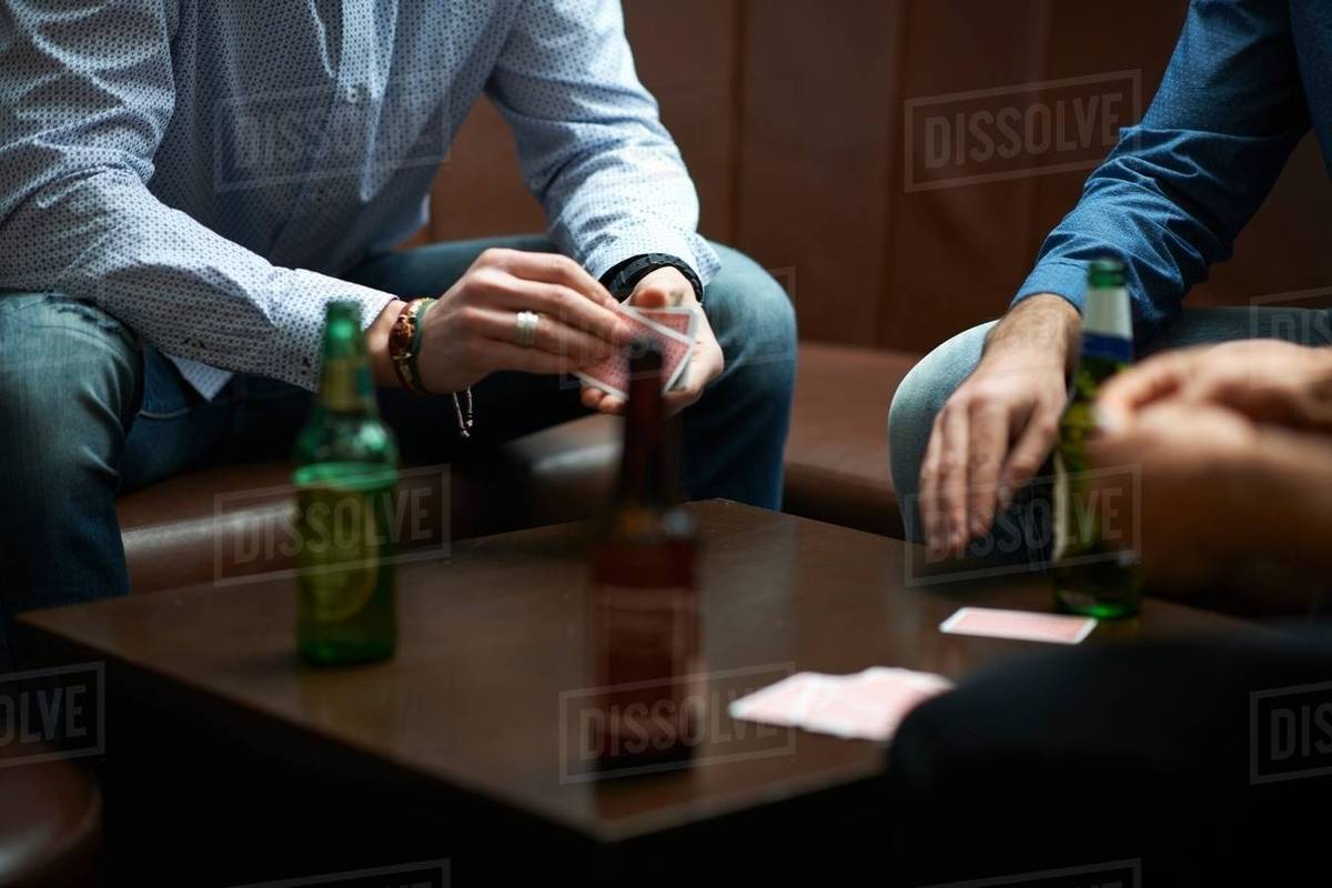 Hands of three men playing cards in traditional UK pub - Royalty-free ...