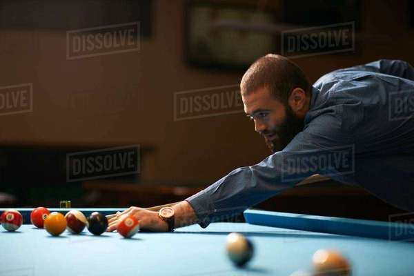Man playing pool - Stock Photo - Dissolve