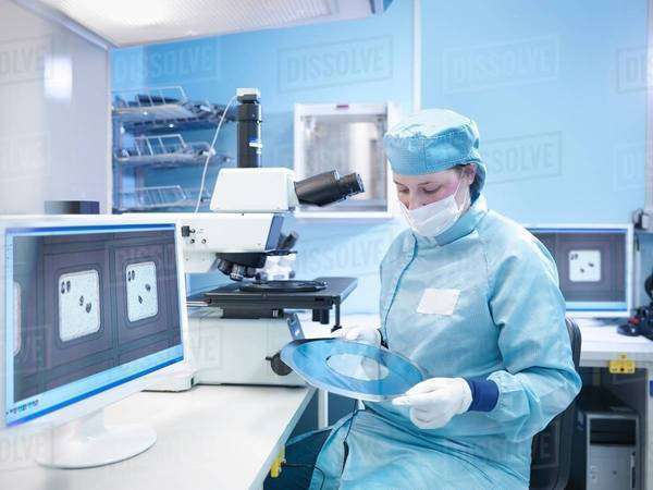 Electronics worker in clean room with silicon wafer - Stock Photo ...