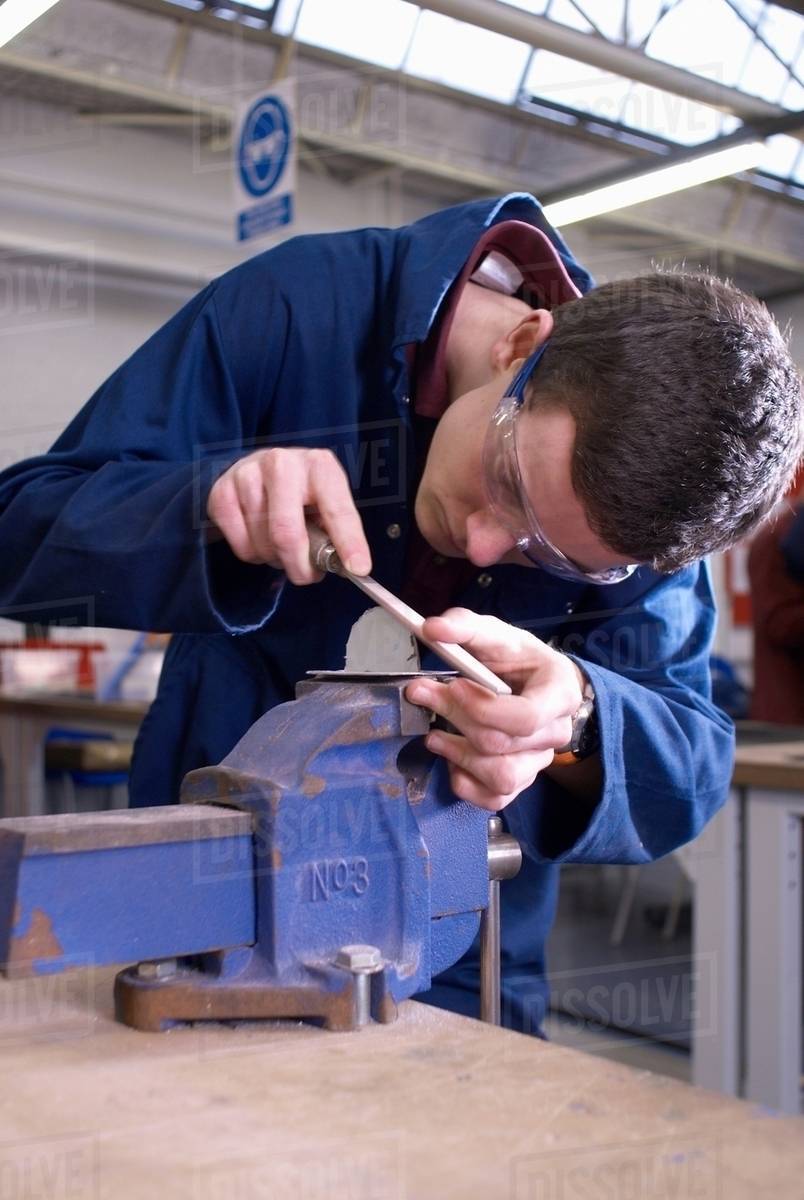Worker using saw in factory - Royalty-free Stock Photo | Dissolve