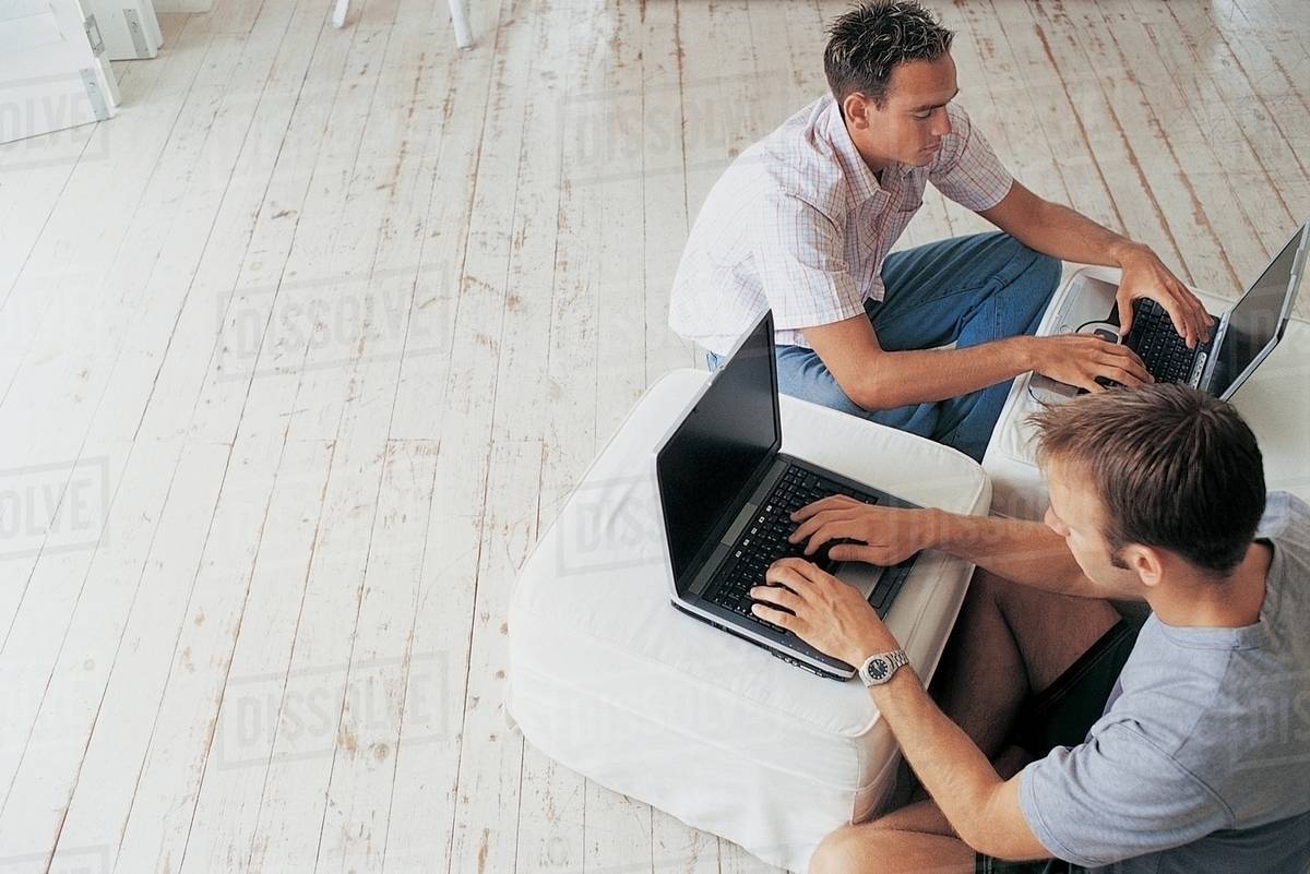 Men using laptops in living room - Royalty-free Stock Photo | Dissolve