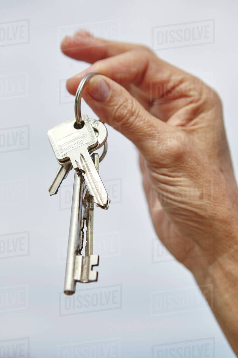 Womans hand holding bunch of keys - Stock Photo - Dissolve