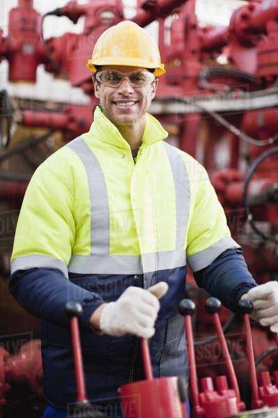 Worker operating machinery on oil rig - Royalty-free Stock Photo | Dissolve