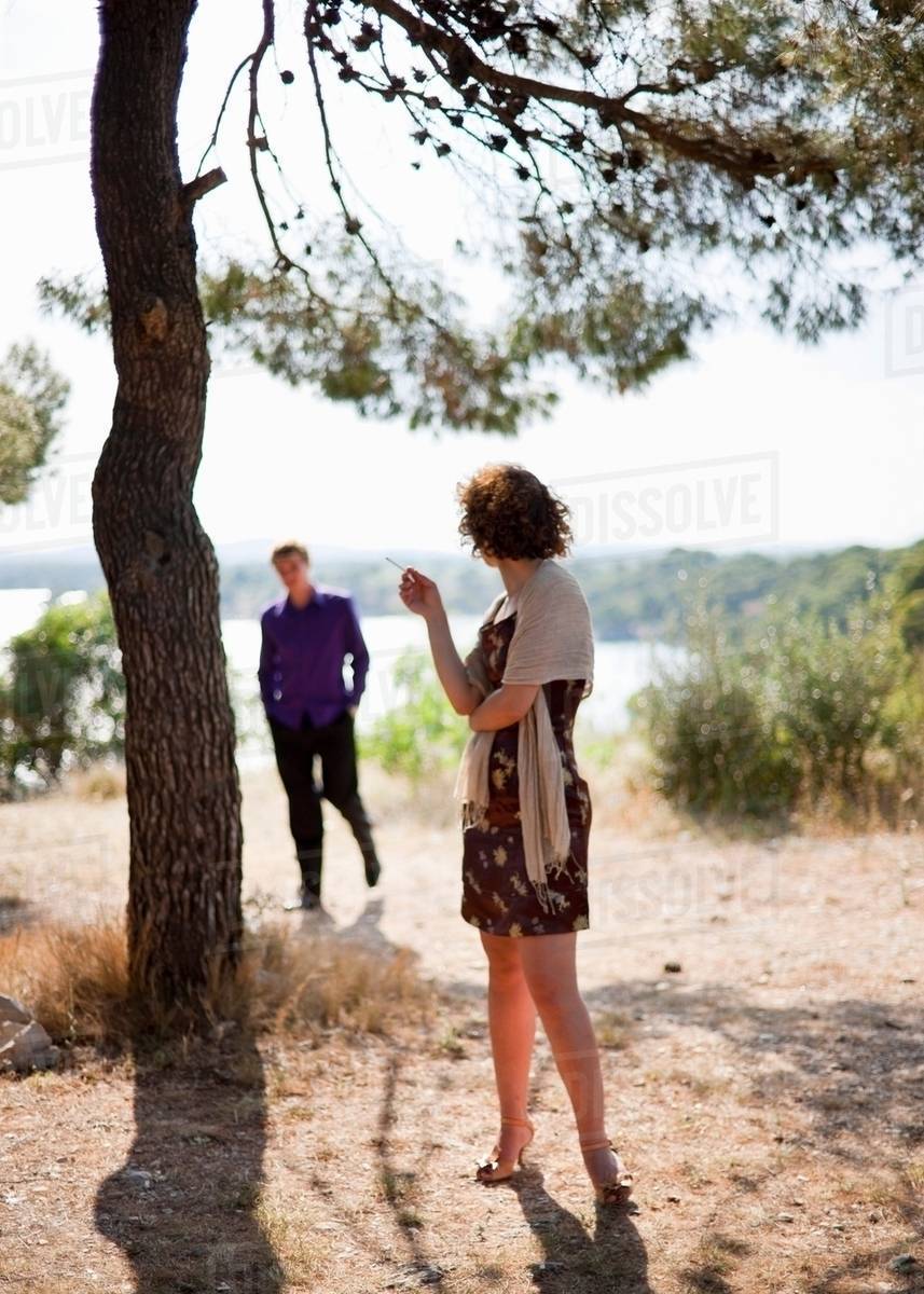Woman smoking a cigarette outdoors - Stock Photo - Dissolve