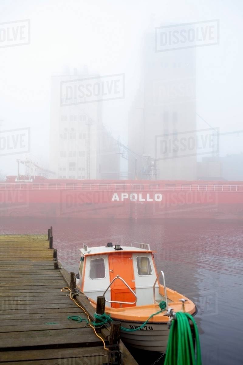 Tugboat docked in urban bay - Royalty-free Stock Photo | Dissolve