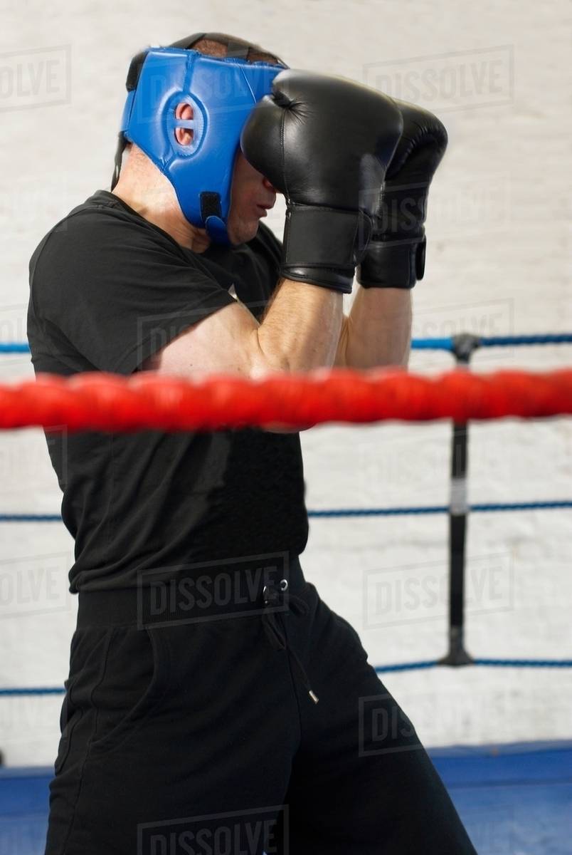 Boxer covering his face in ring - Royalty-free Stock Photo | Dissolve