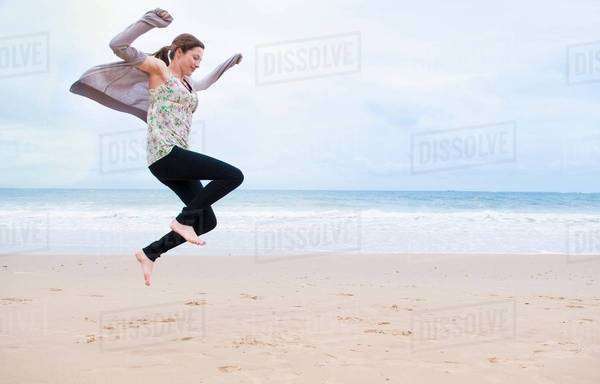Woman jumping on beach - Royalty-free Stock Photo | Dissolve