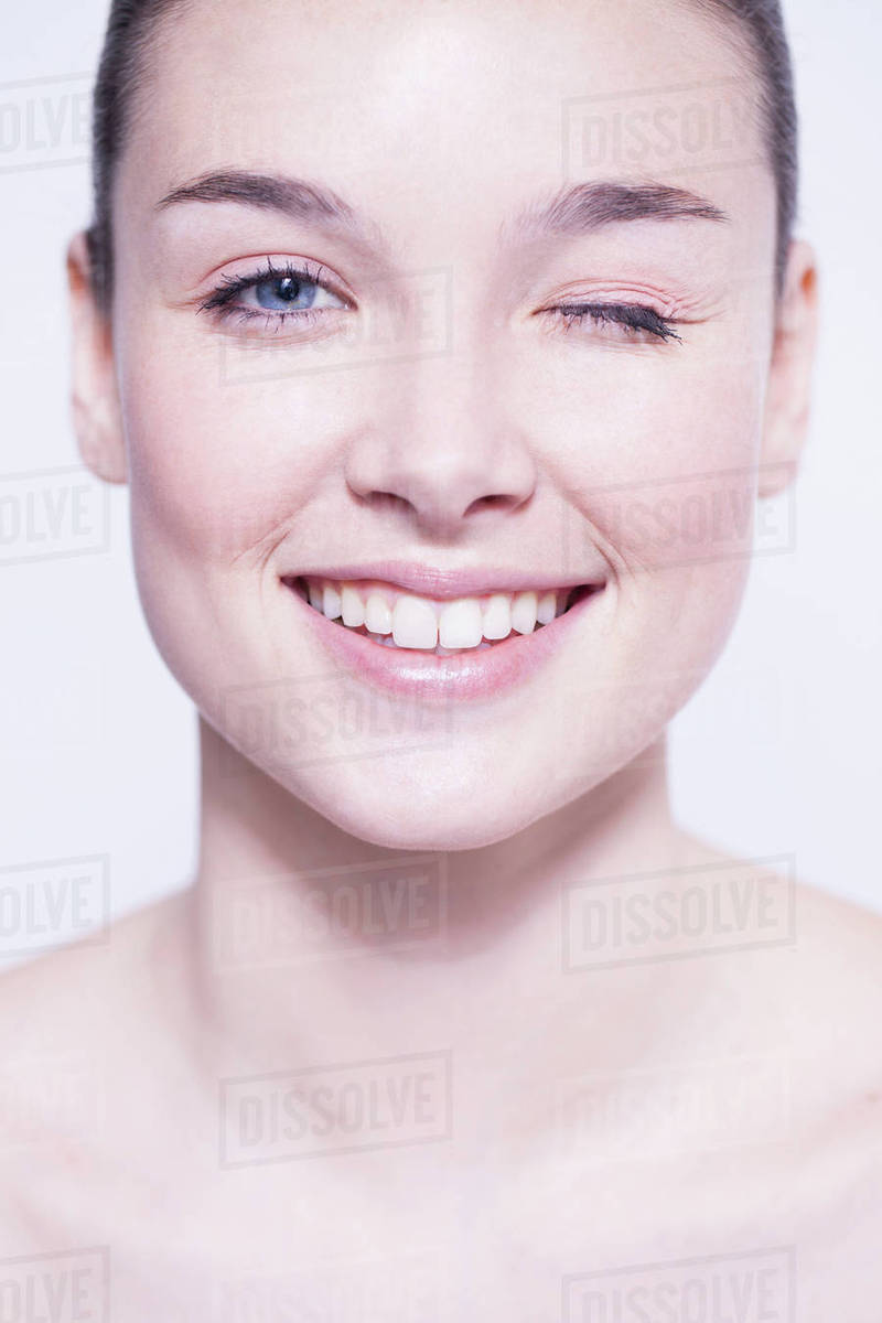 Head and shoulder shot of beautiful young woman winking - Royalty-free ...
