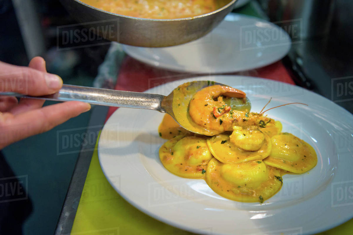 Chef plating up lobster ravioli in traditional Italian restaurant ...