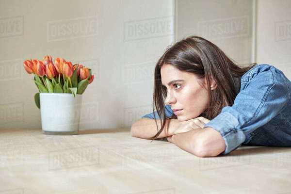 Young woman leaning forward on dining table - Stock Photo - Dissolve