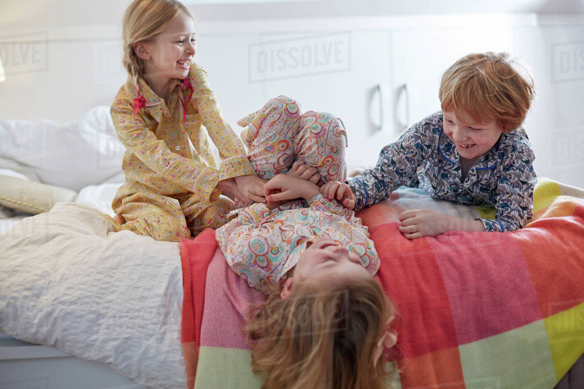 Children playing in bed - Royalty-free Stock Photo | Dissolve