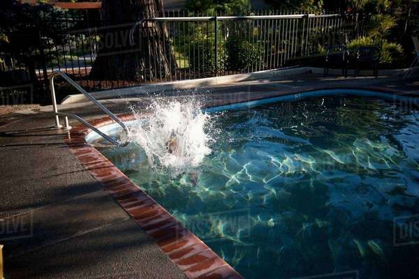 Person diving into swimming pool - Stock Photo - Dissolve