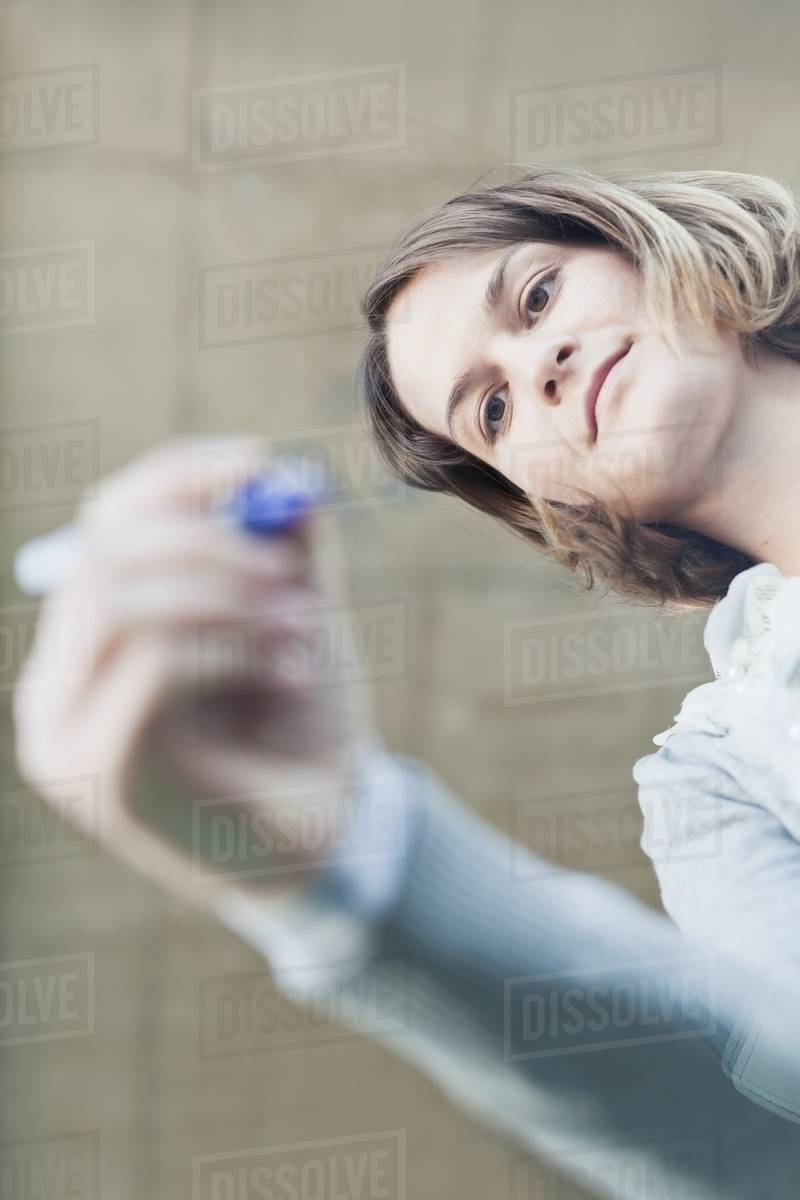 Woman writing on glass with marker - Royalty-free Stock Photo | Dissolve