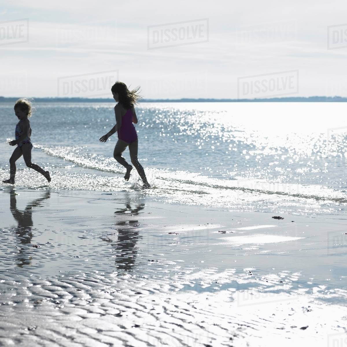 Children playing in waves on beach - Royalty-free Stock Photo | Dissolve
