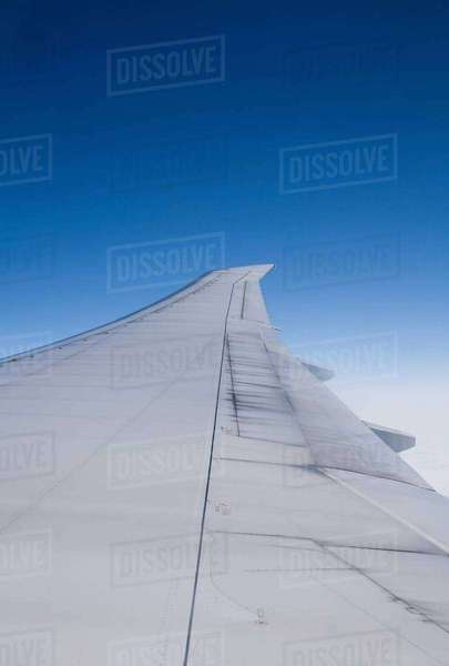 Airplane wing seen from inside commercial jet - Stock Photo - Dissolve