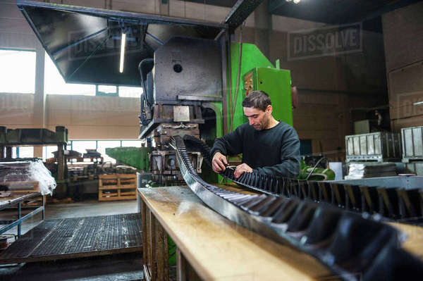Man working in manufacturing plant on rubber production line - Stock ...