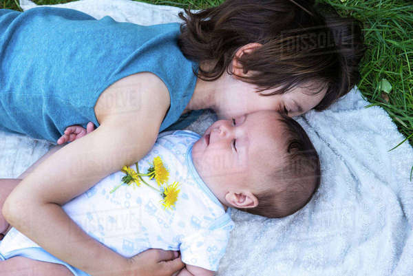Boy hugging baby brother in garden - Royalty-free Stock Photo | Dissolve