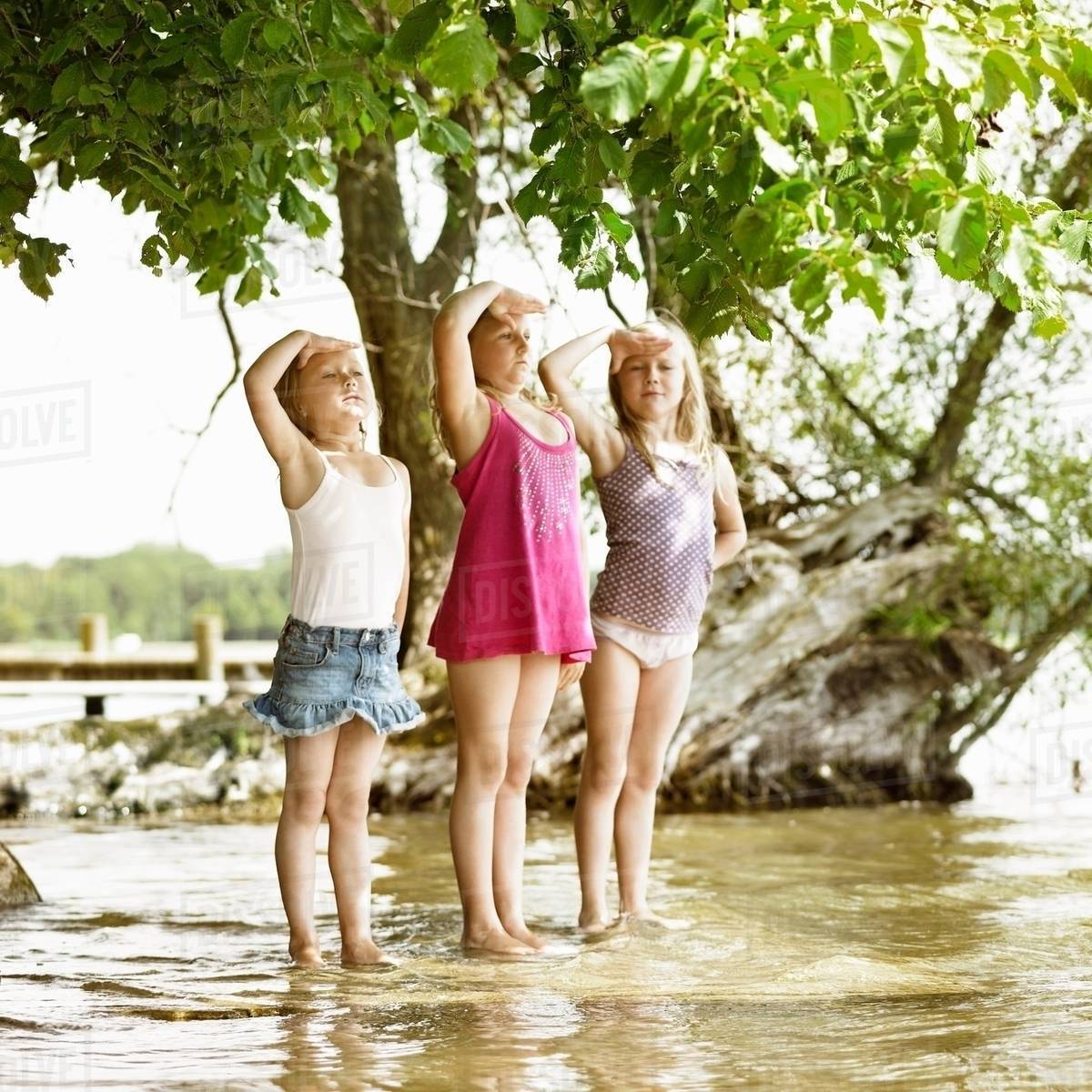 Smiling girls playing in lake - Stock Photo - Dissolve